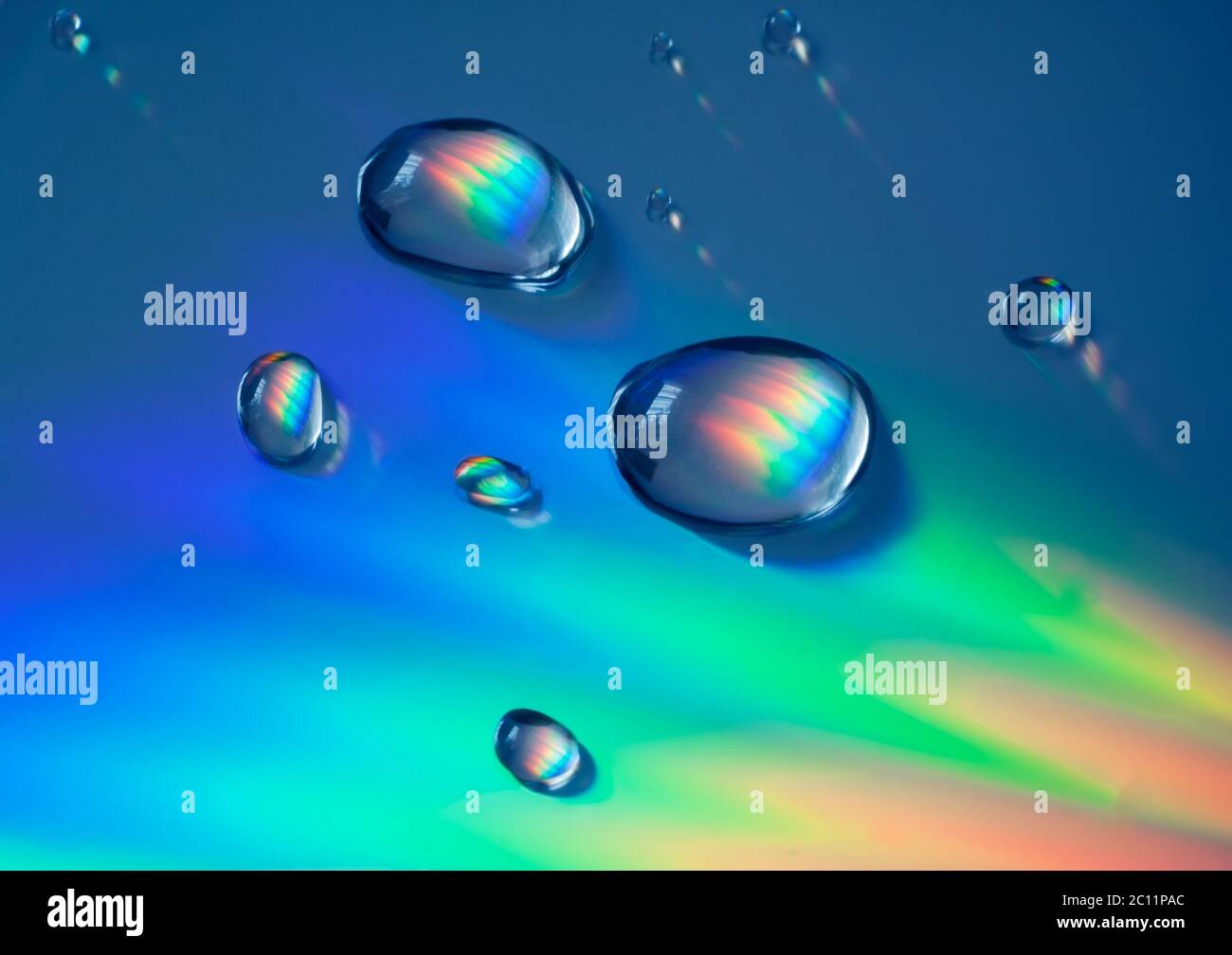 Closeup of rainbow colored reflection and water droplets on CD Stock ...