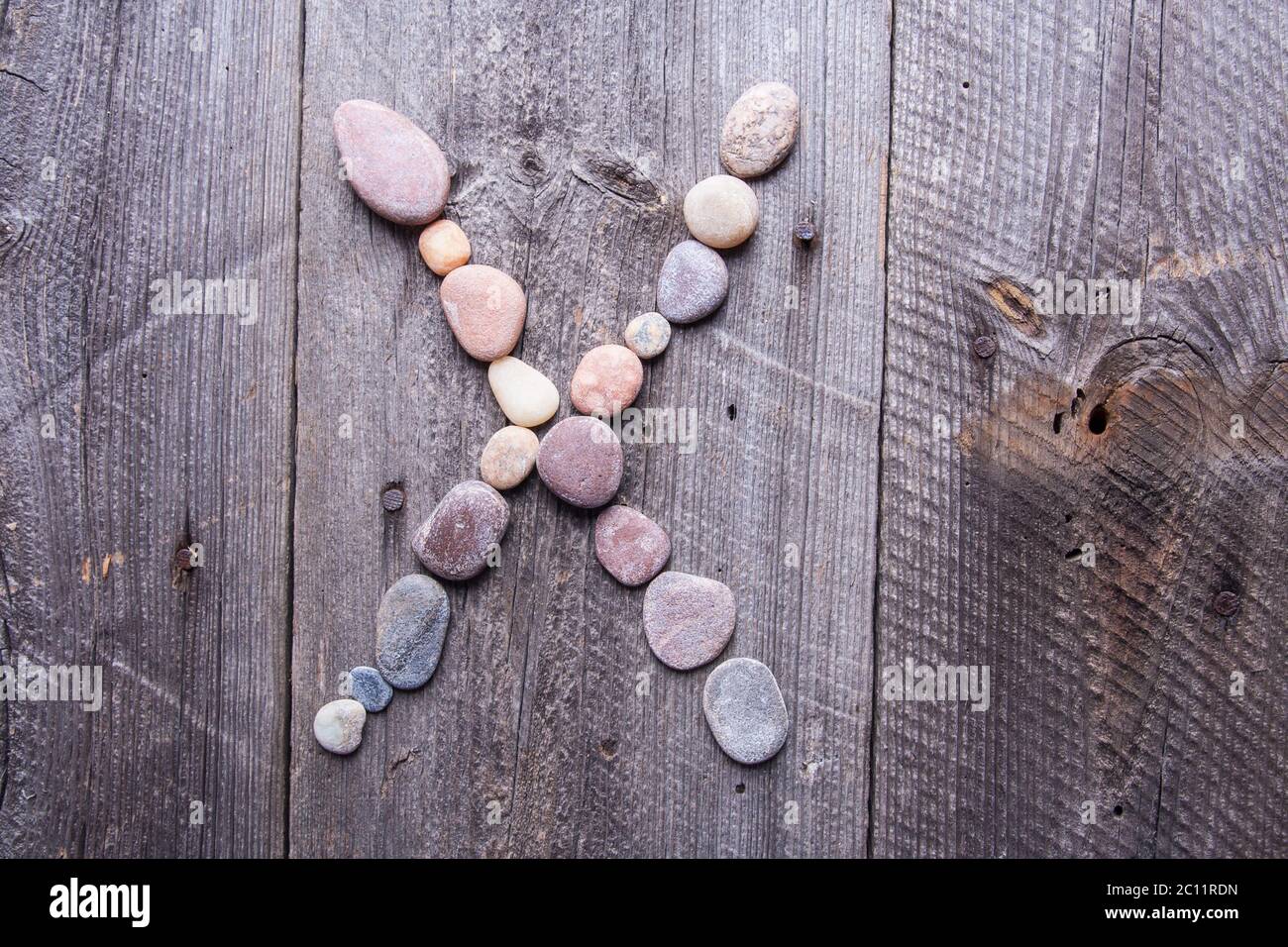 X - Letter alphabet stones laid out on the old wood Stock Photo - Alamy