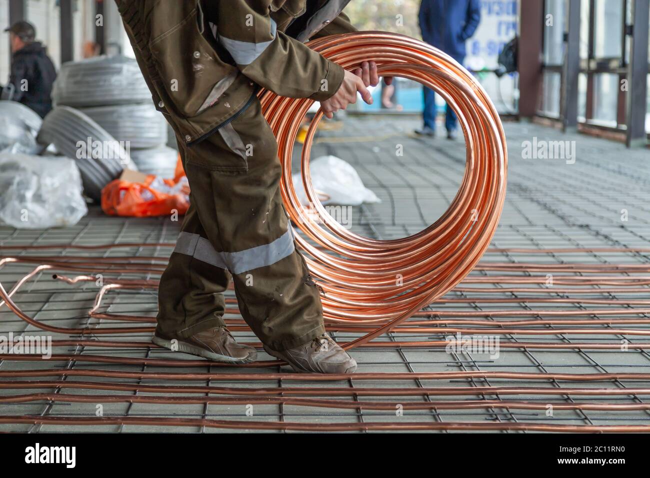 Plumber laying copper pipes on floor with warm heating Stock Photo - Alamy
