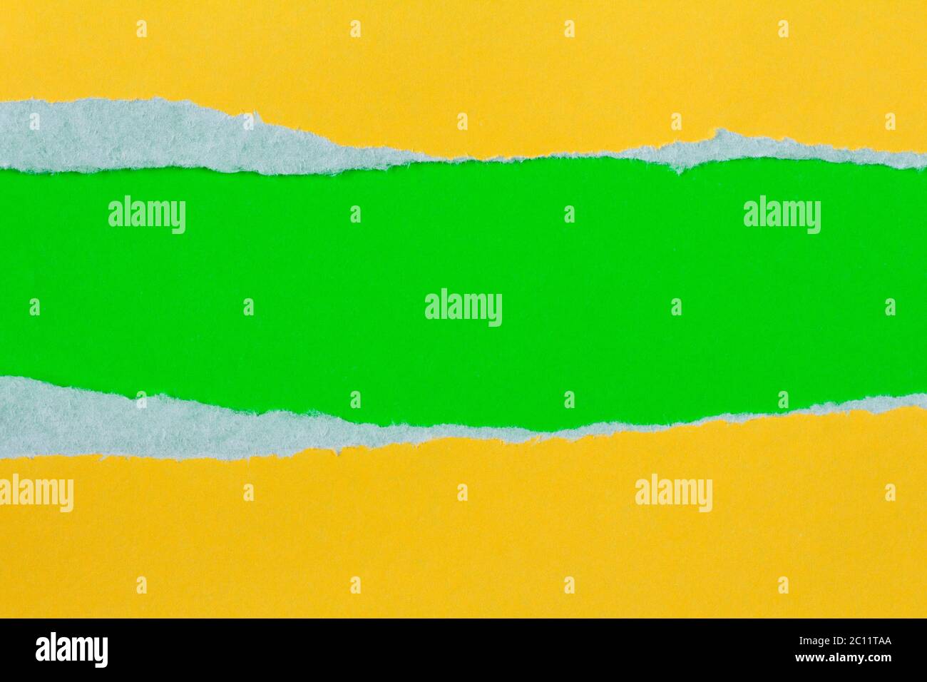 Torn yellow paper with a green background Stock Photo - Alamy