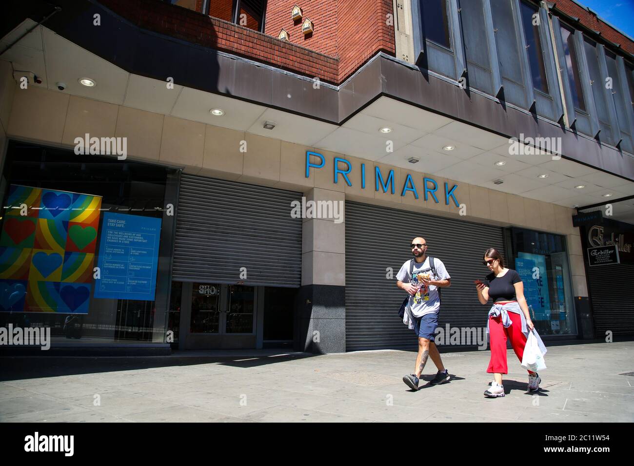 London, UK. 13th June, 2020. Shoppers walk past a branch of Primark ...