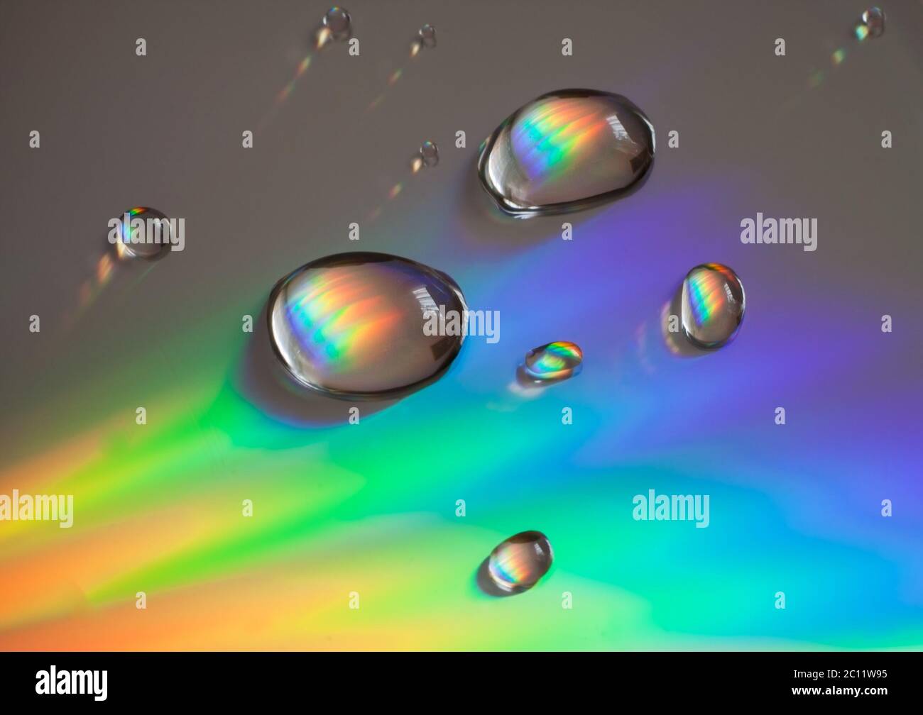 Closeup of rainbow colored reflection and water droplets on CD Stock ...