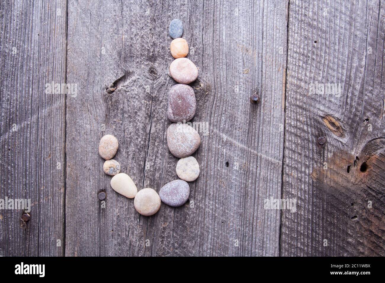 J - Letter alphabet stones laid out on the old wood Stock Photo - Alamy