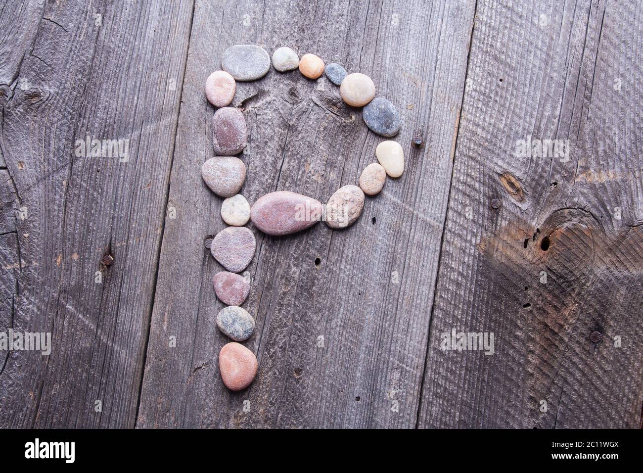 P - Letter alphabet stones laid out on the old wood Stock Photo - Alamy