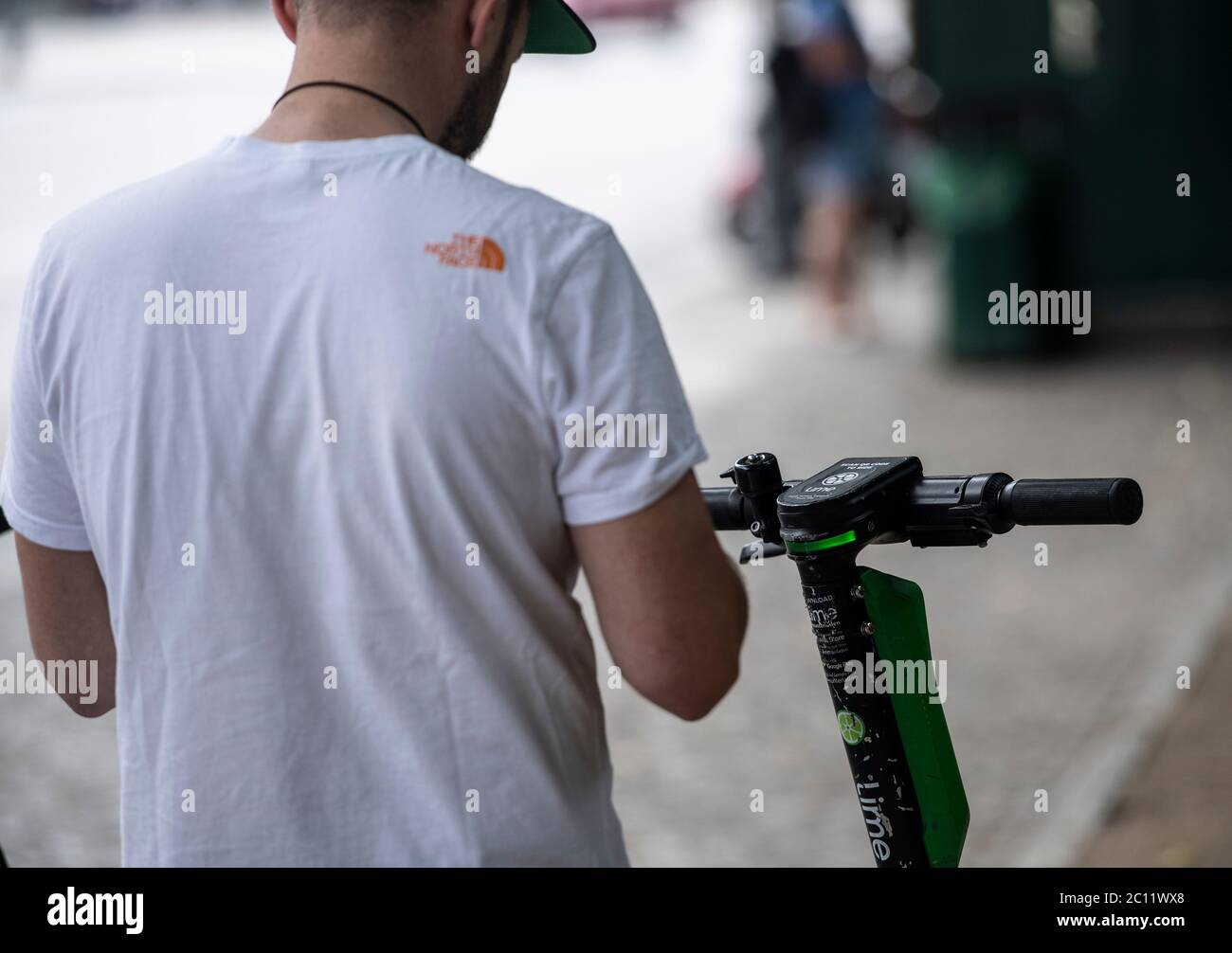 Berlin, Germany. 12th June, 2020. A man borrows an electric scooter from Lime. Credit: Paul ...