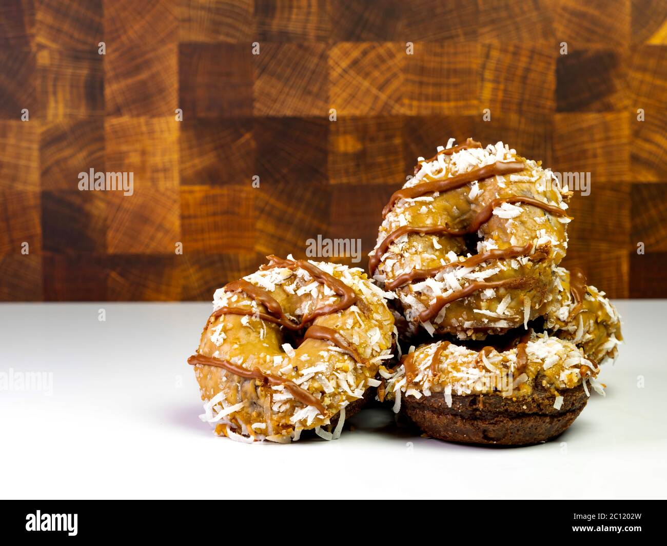 Pile of German chocolate donuts / doughnnuts On a white counter with a ...