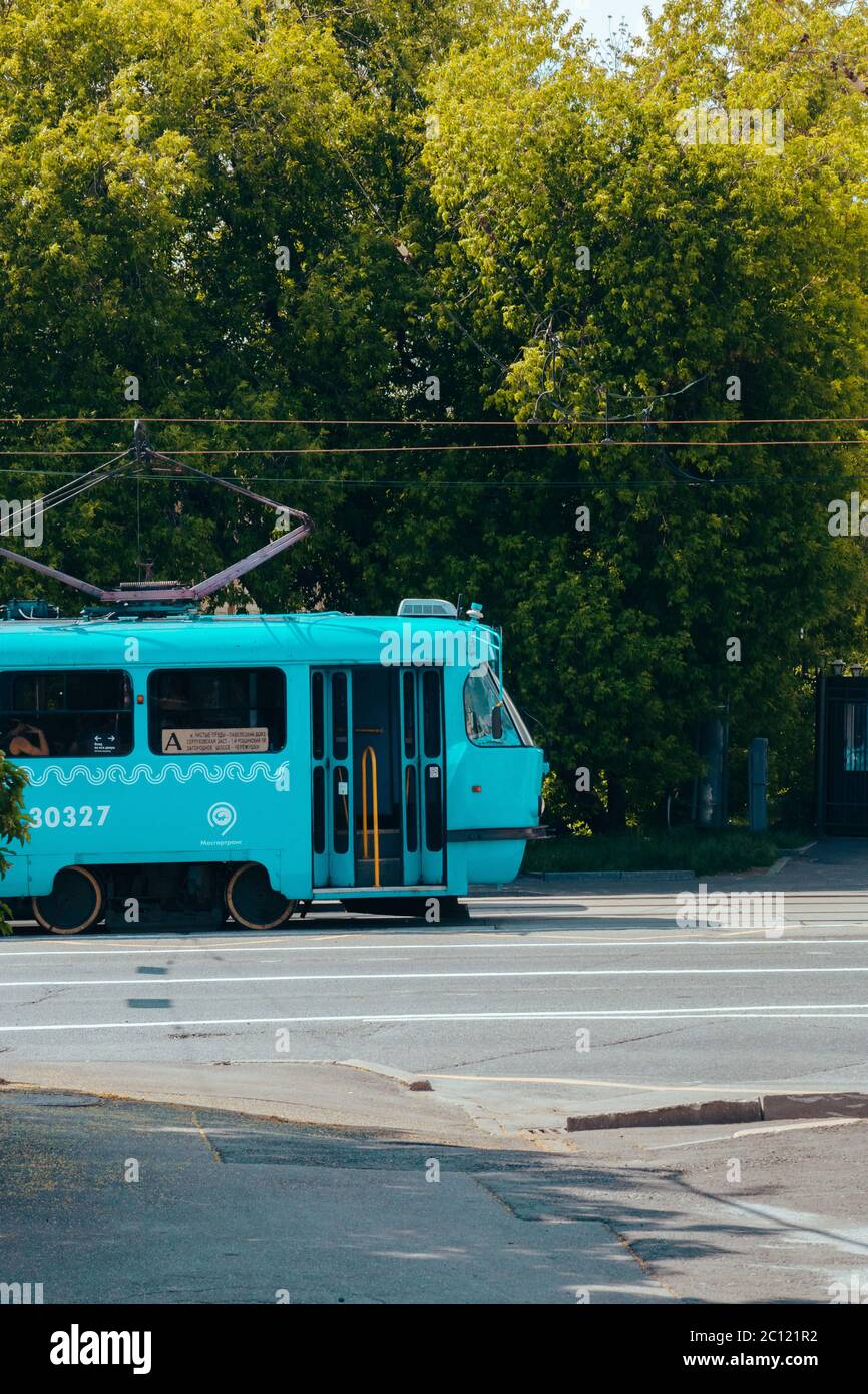 Public transport blue tram with opening doors with passengers inside ...