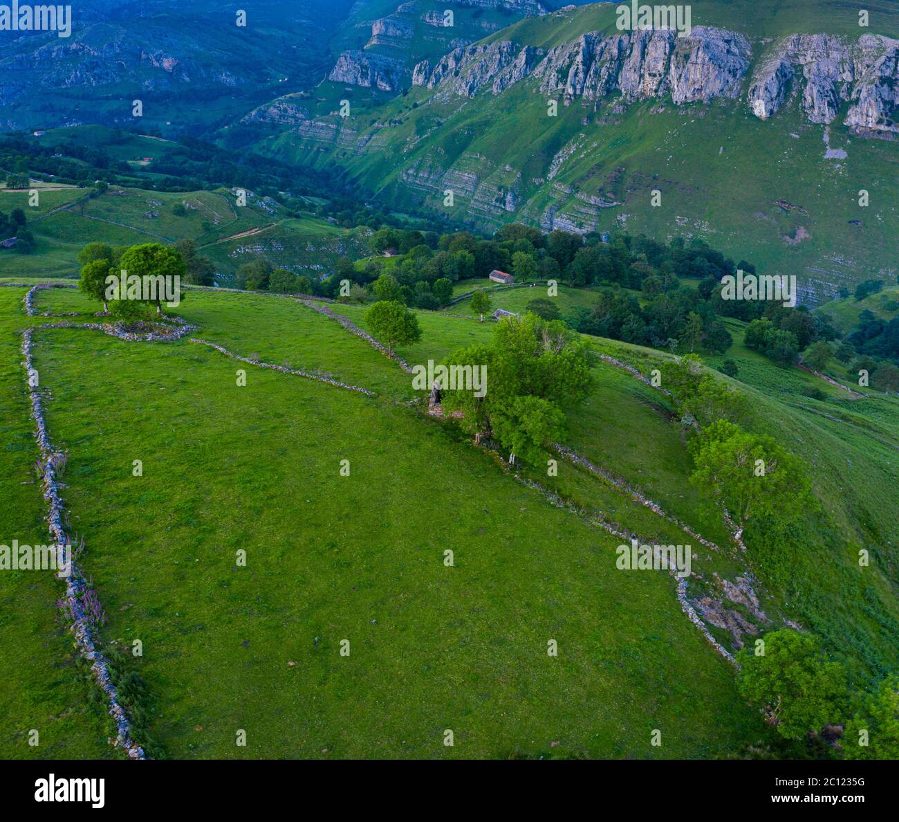 Spring landscape of mountains, meadows of mowing and cabins pasiegas in ...