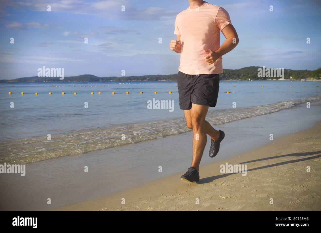 Man running on the beach at sunrise Stock Photo - Alamy
