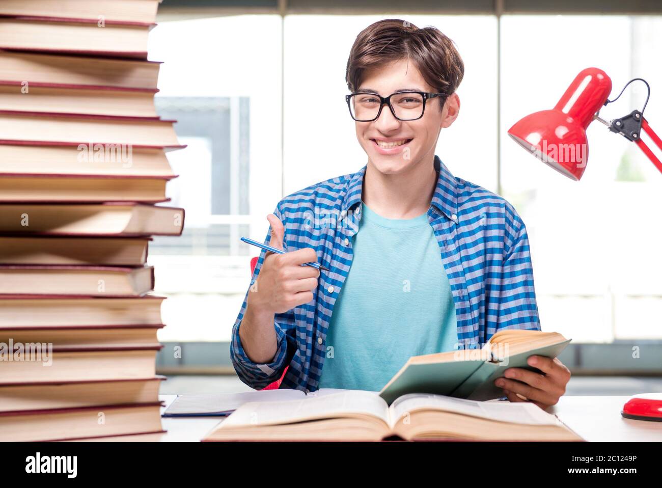 Student with lots of books preparing for exams Stock Photo - Alamy