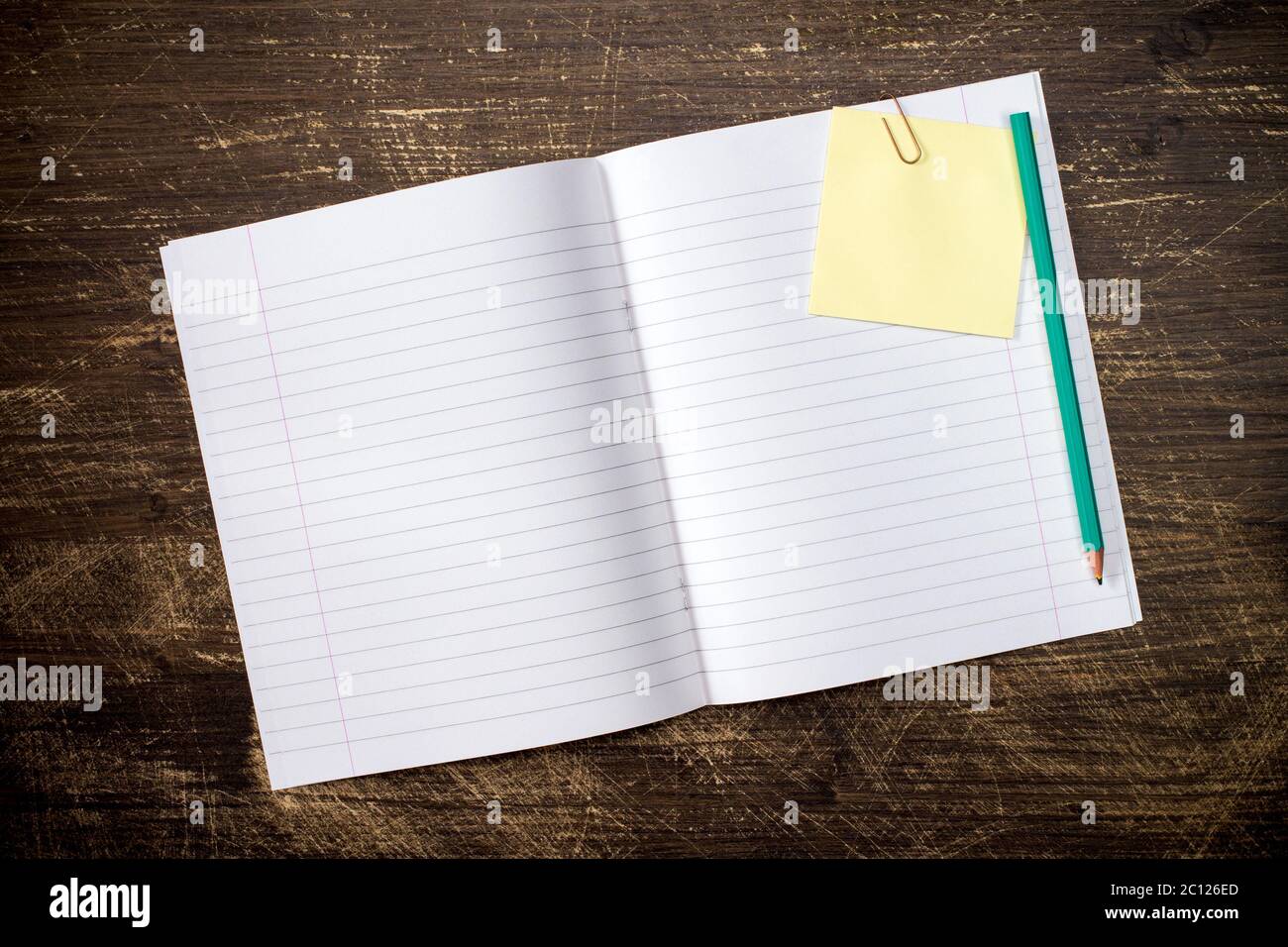 Exercise-book with sticky note and pencil Stock Photo - Alamy