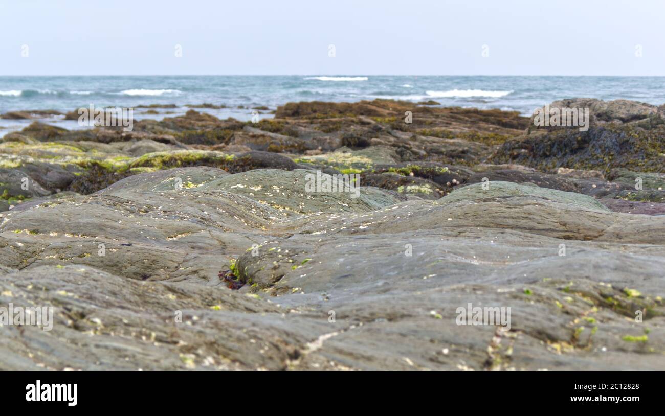 Rocks, pebbles, rock pools, sand and ocean on an overcast June day in ...
