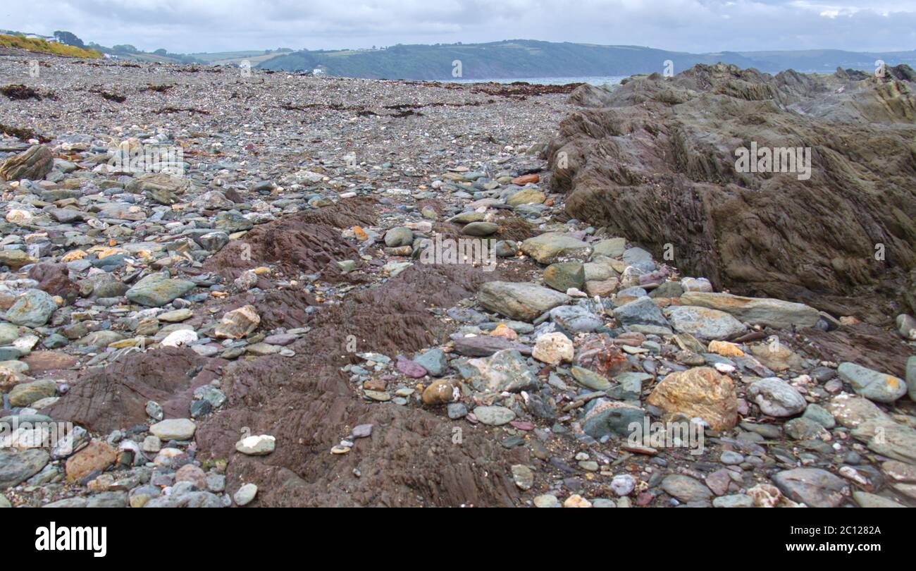 Rocks, pebbles, rock pools, sand and ocean on an overcast June day in ...