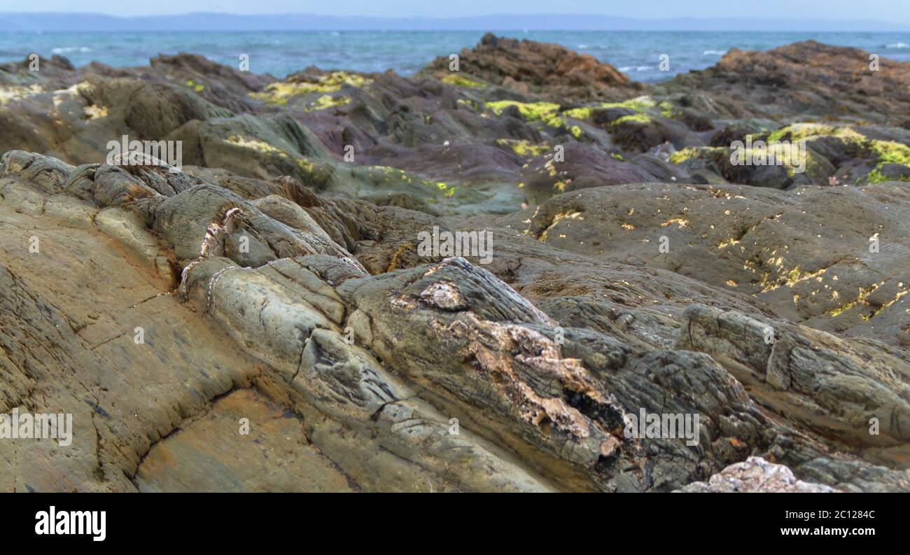 Rocks, pebbles, rock pools, sand and ocean on an overcast June day in ...