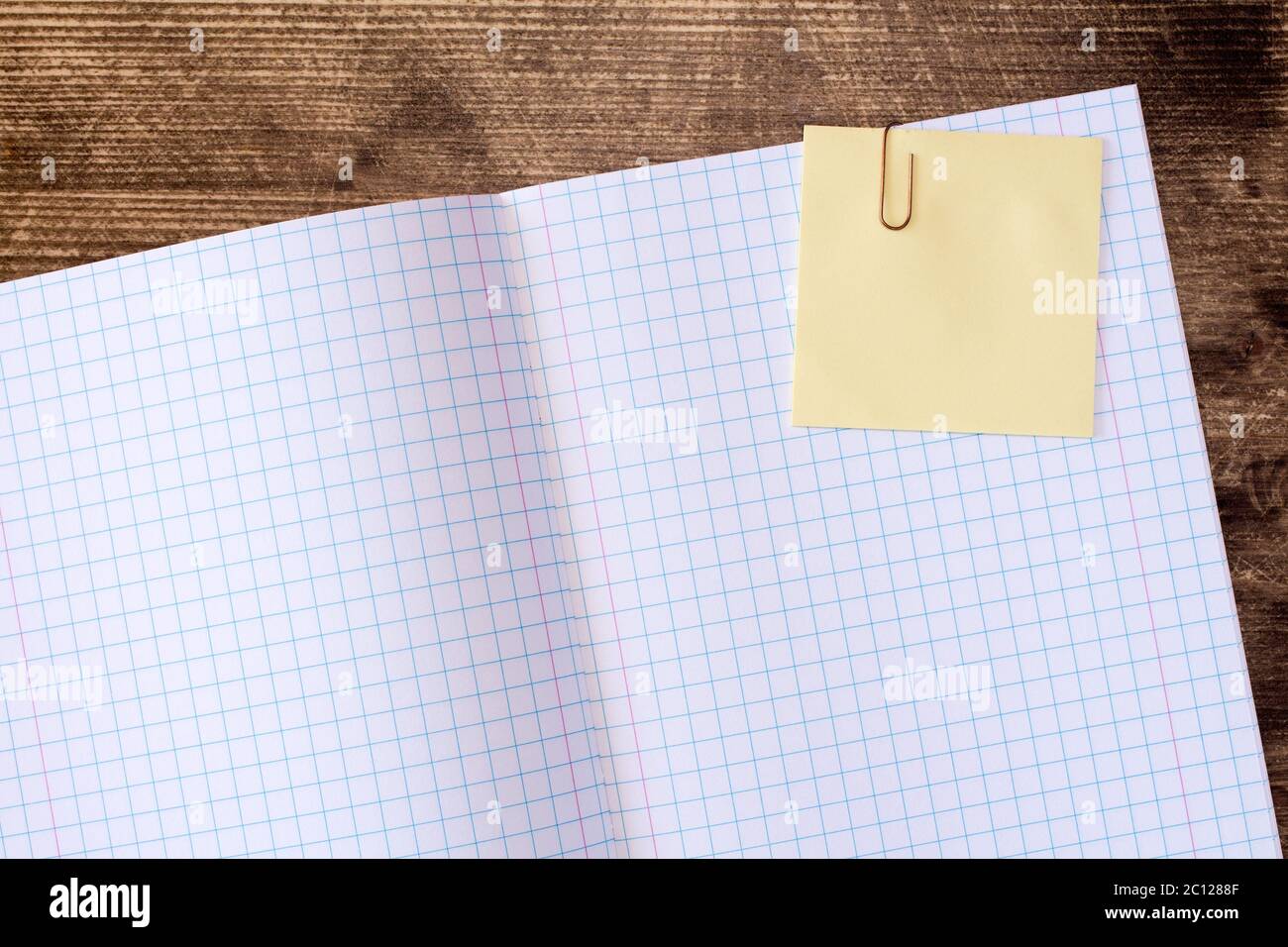 Squared exercise book with sticky note Stock Photo - Alamy
