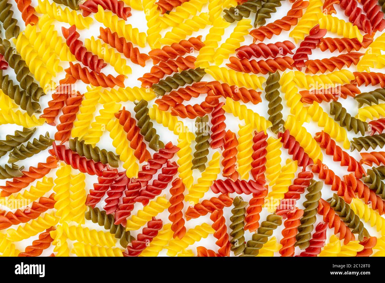 Background made of many colorful spiral macaroni lying on white ...