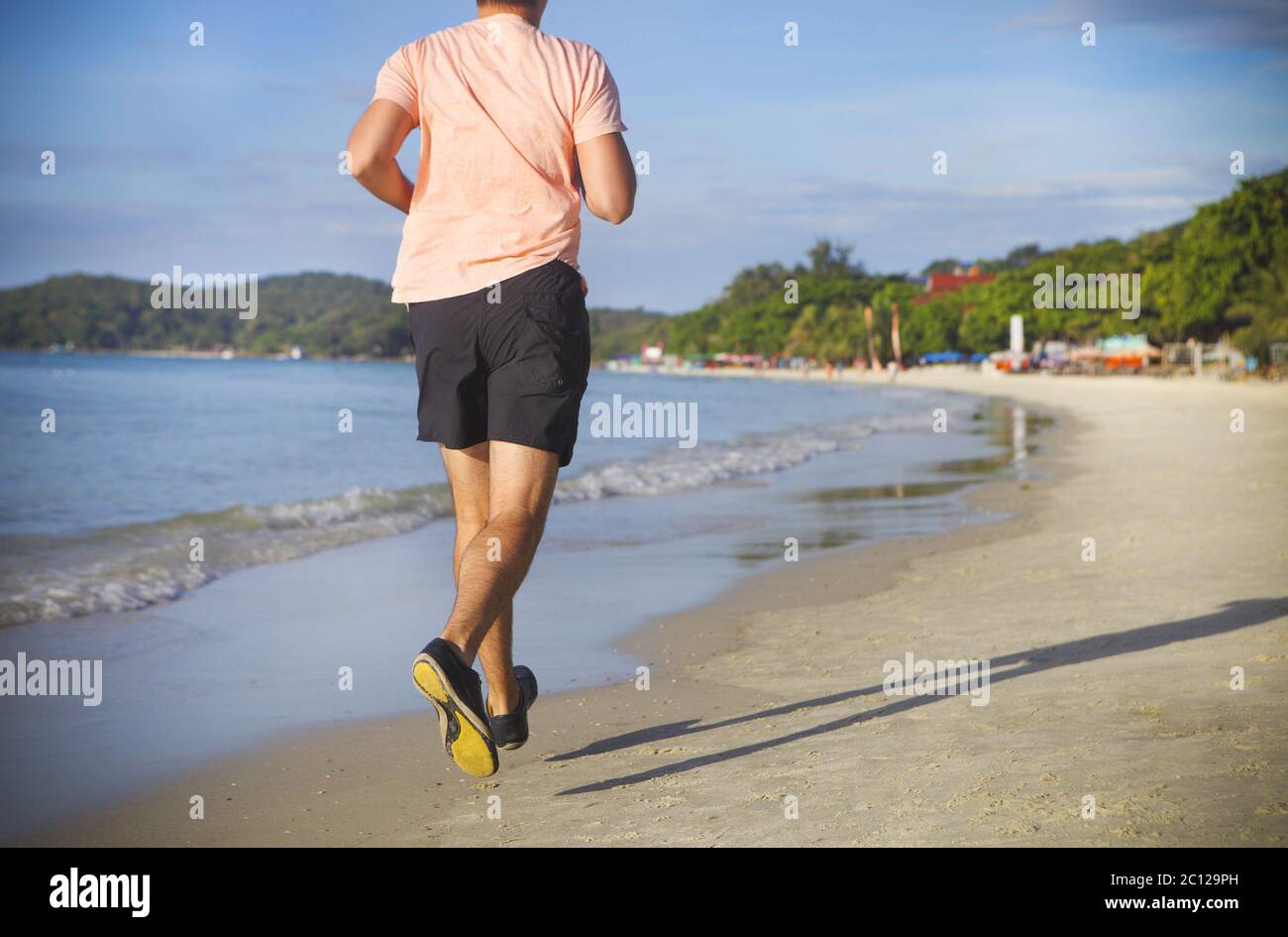 Man running on the beach at sunrise Stock Photo - Alamy