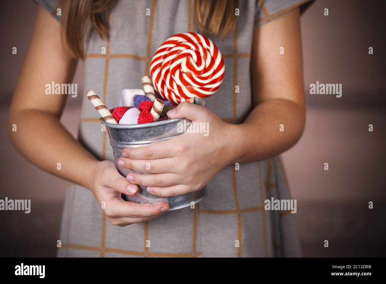 Bucket with colorful candies in the hands of little girl Stock Photo ...