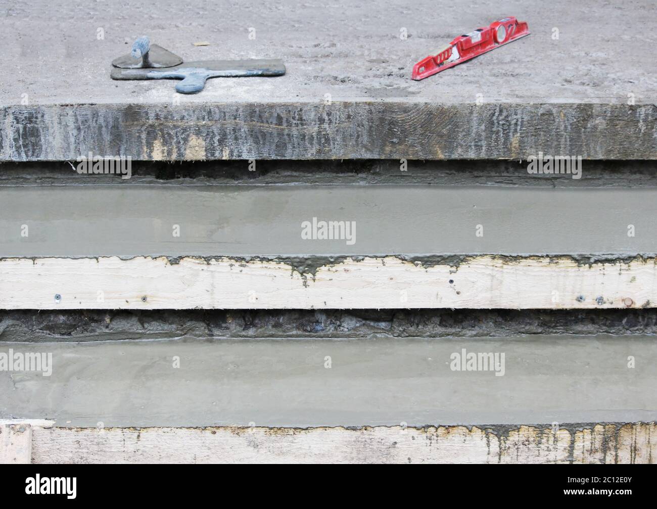 Tools: Two trowel, level on the steps and wooden formwork filled with ...