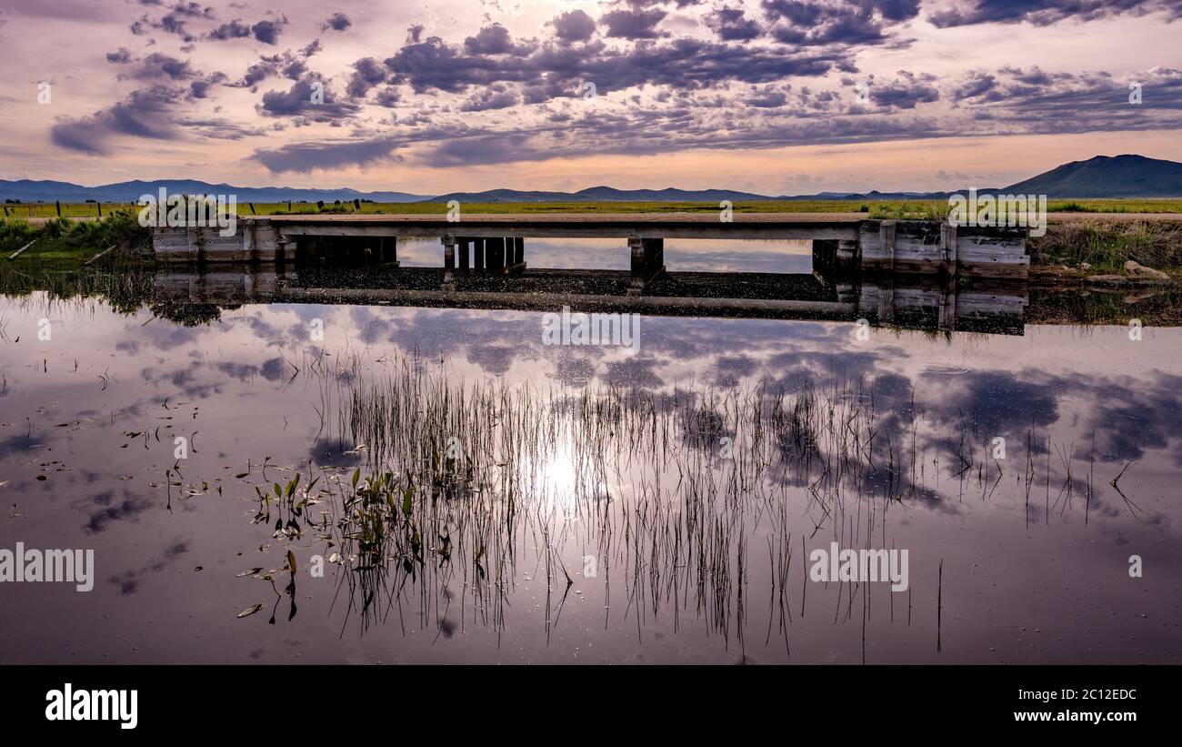 Warm colors in the sky above a wood bridge reflection Stock Photo - Alamy