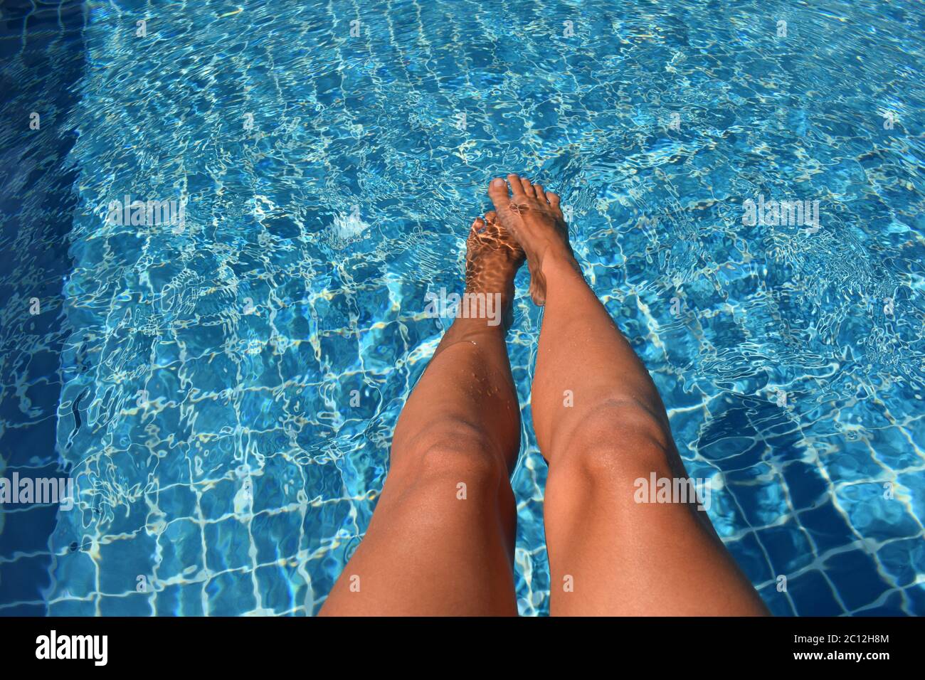 Female legs dipped in a blue swimming pool Stock Photo - Alamy
