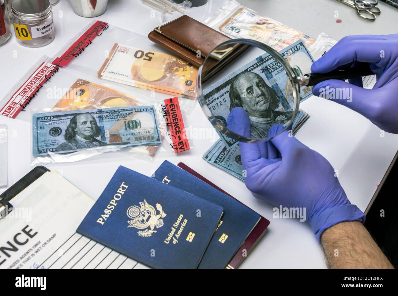 Police scientist investigates fake dollar bills and passports in ...