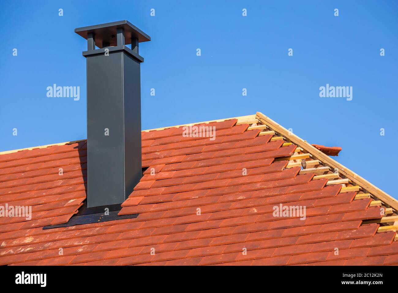 A roof under construction with stacks of roof tiles ready to fasten ...