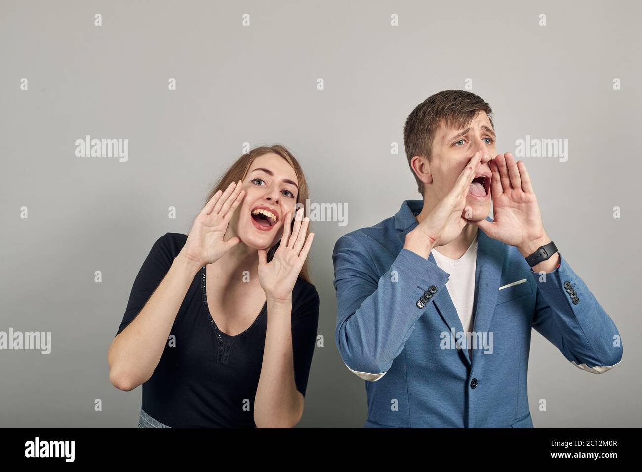 Scream and shout holding hands near opened mouth. Screaming loudly with ...