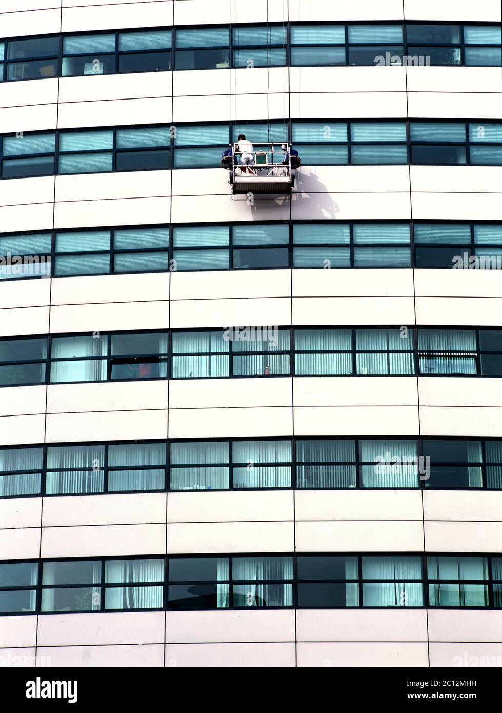 Window cleaner at work in a scaffold on side of skyscraper Stock Photo ...