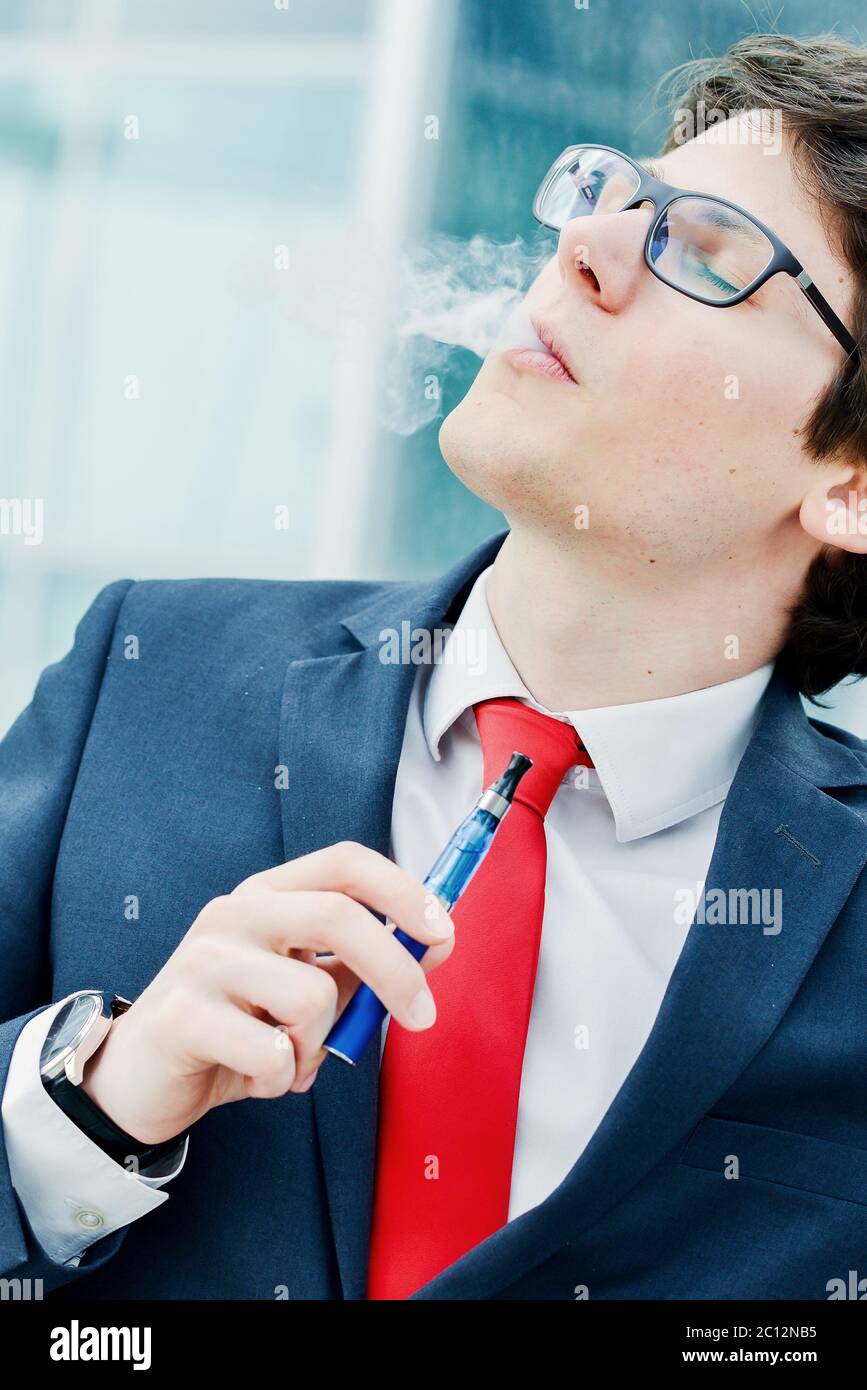 Portrait of cheerful guy smoking with e-cigarette Stock Photo - Alamy