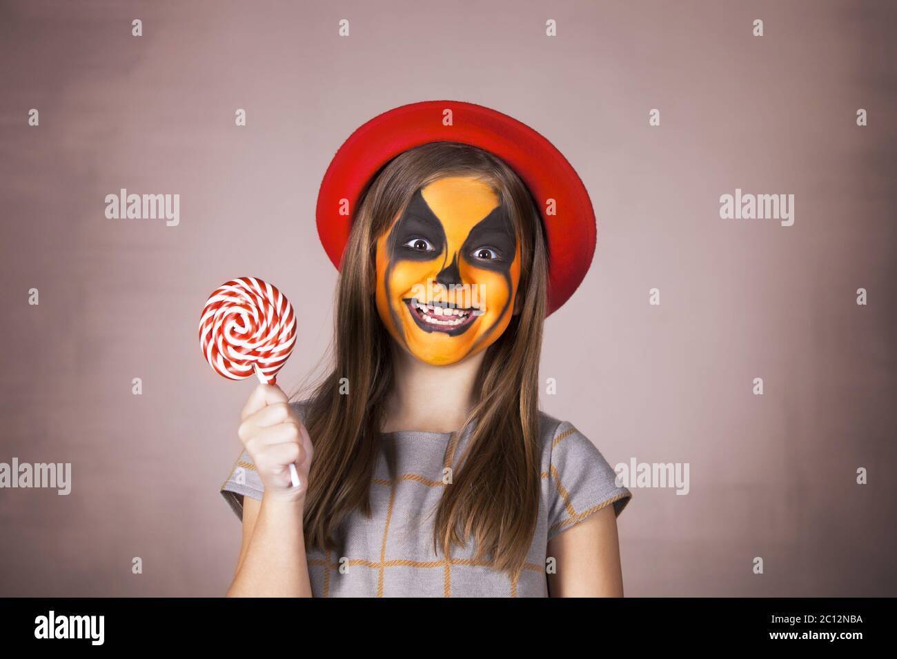 Pretty girl with face painting of a pumpkin Stock Photo - Alamy