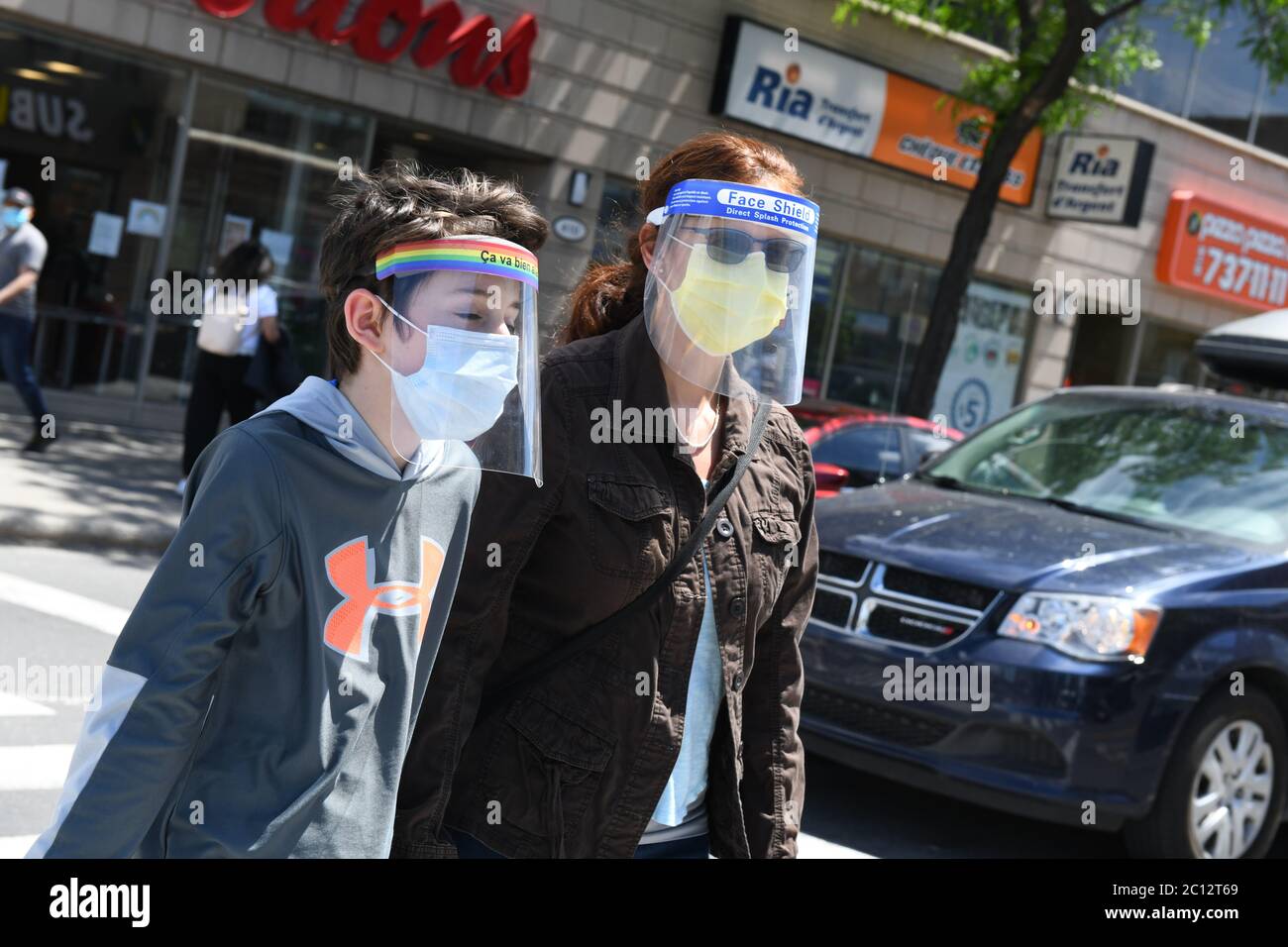 Mother and son wearing protective face masks and face shields during ...