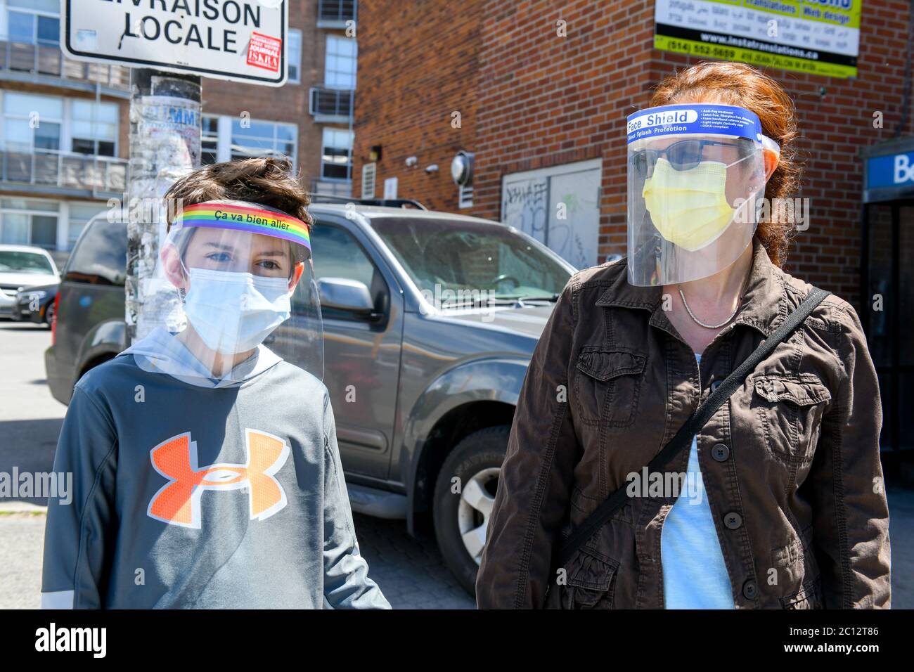 Mother and son wearing protective face masks and face shields during ...