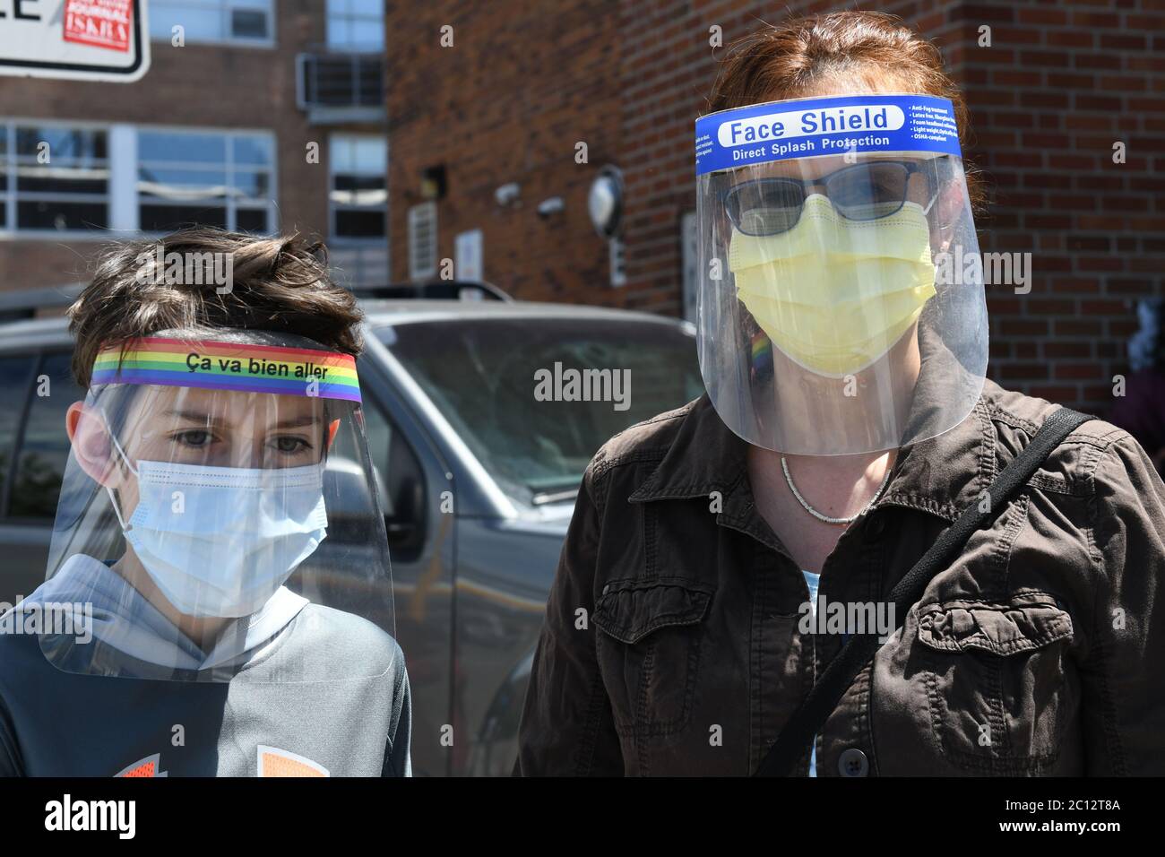 Mother and son wearing protective face masks and face shields during ...