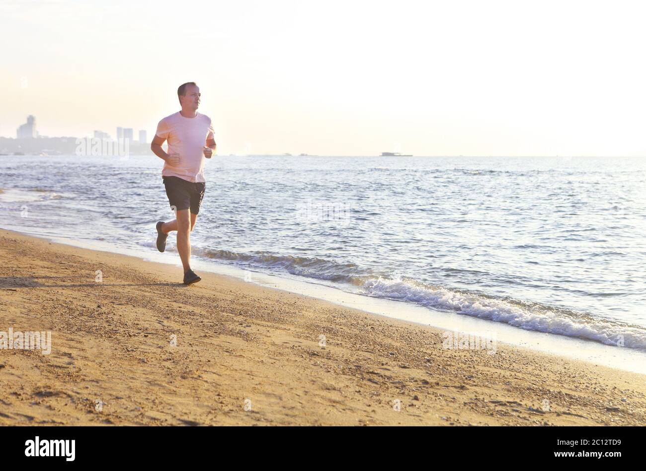 Man running on the beach at surise Stock Photo - Alamy