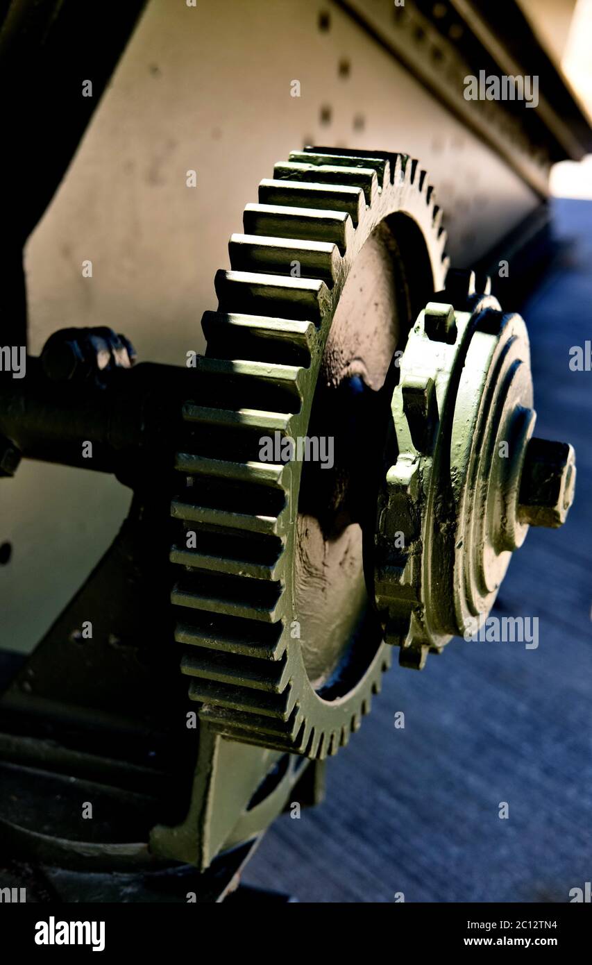 A set of industrial steel gears attached to a heavy duty green ...