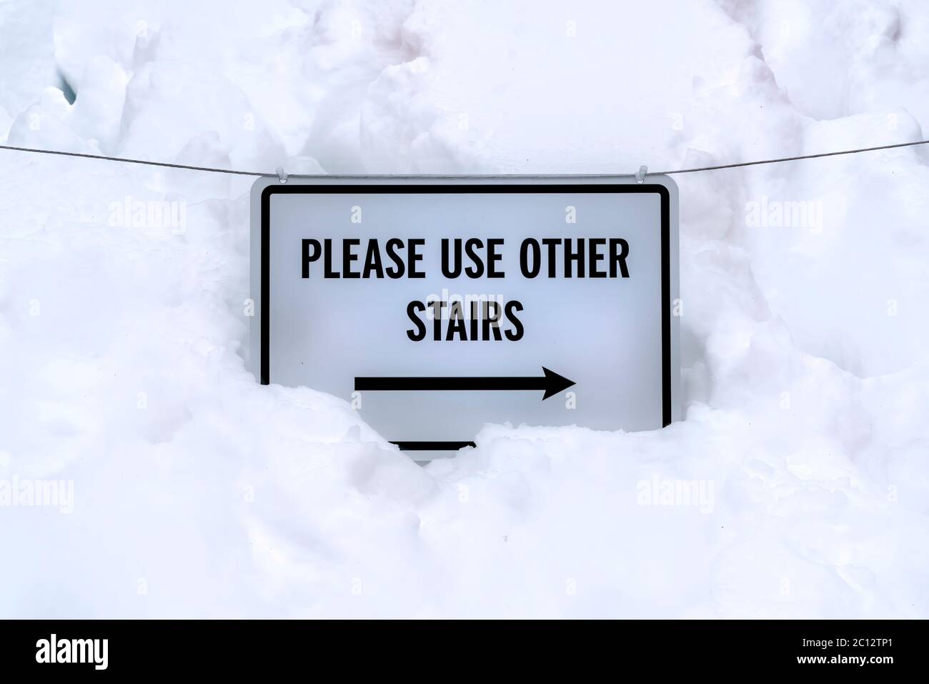Sign that reads Please Use Other Stairs against fresh white snow in ...