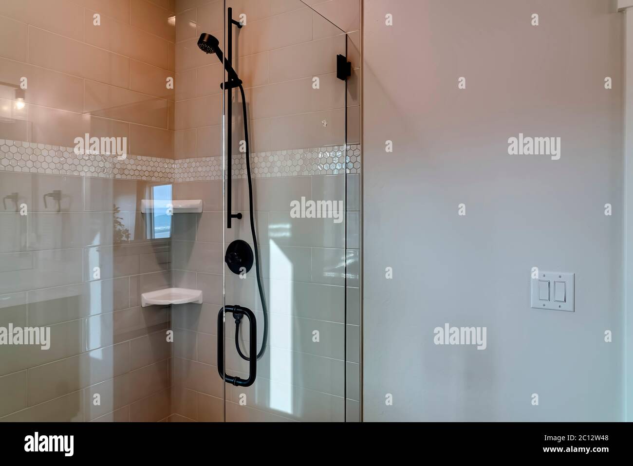 Shower stall with frameless glass enclosure and hinged door inside ...