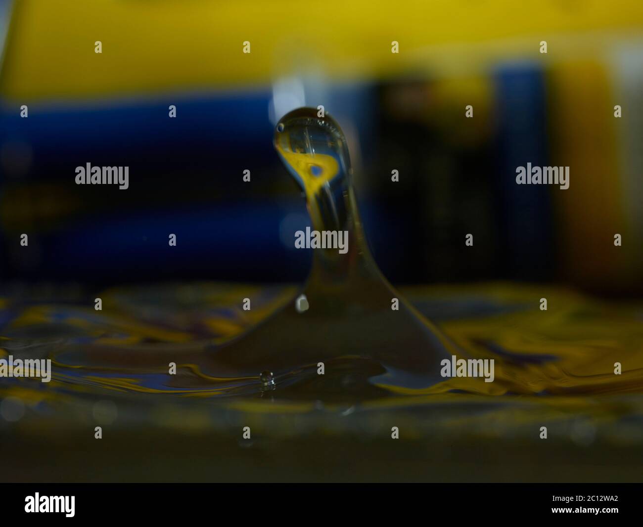 Water droplets falling on and bouncing off a pool of water, leaving ...