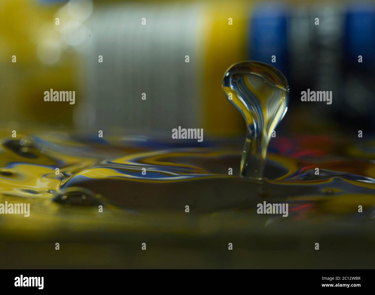 Water droplets falling on and bouncing off a pool of water, leaving ...