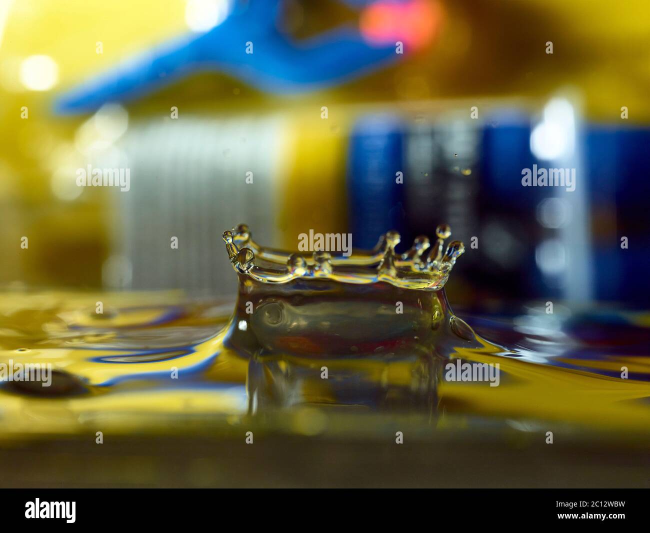 Water droplets falling on and bouncing off a pool of water, leaving ...