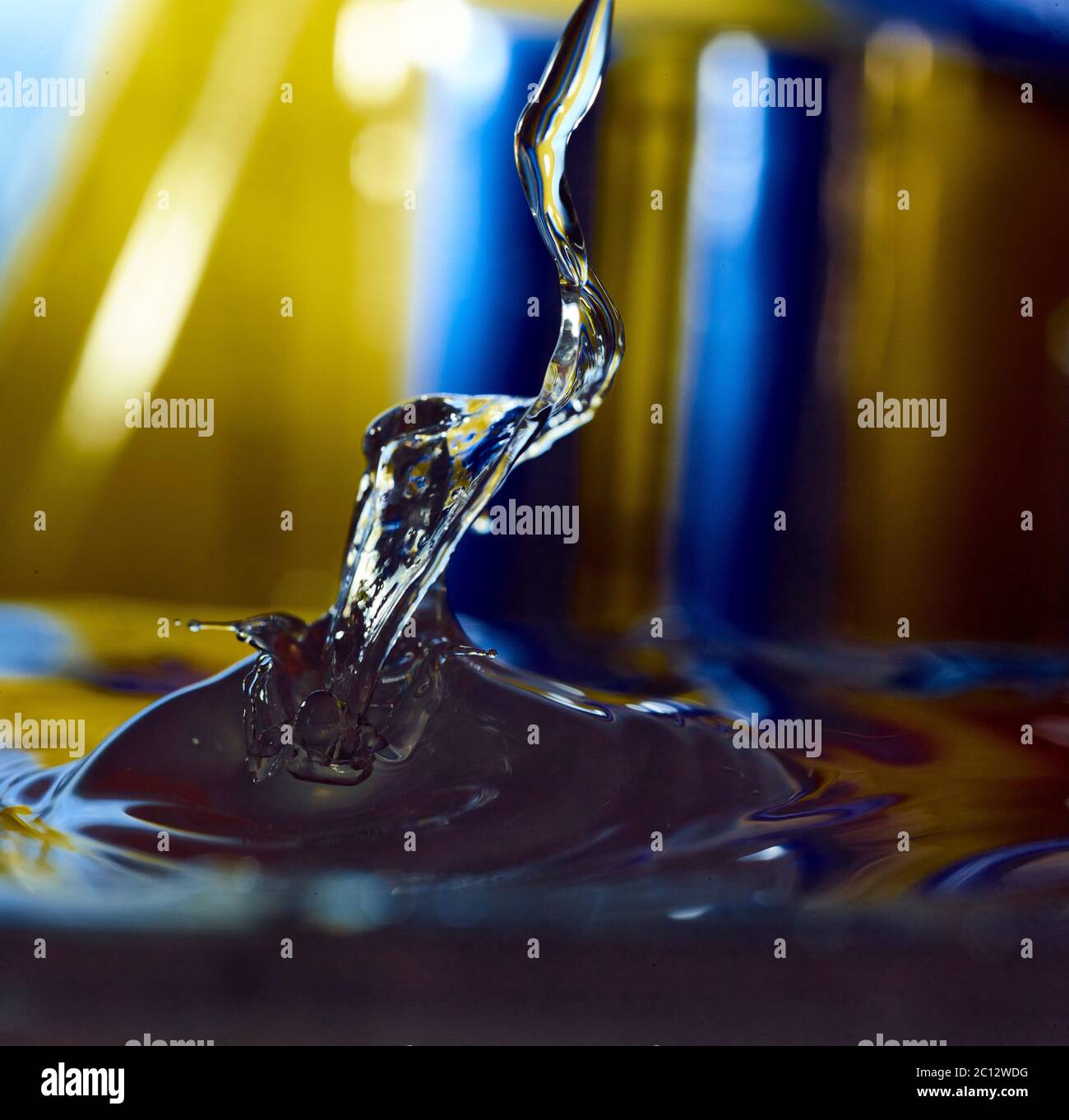Water droplets falling on and bouncing off a pool of water, leaving ...