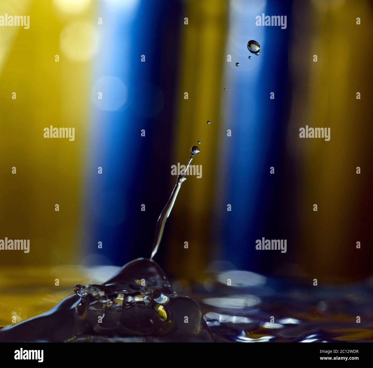 Water droplets falling on and bouncing off a pool of water, leaving ...