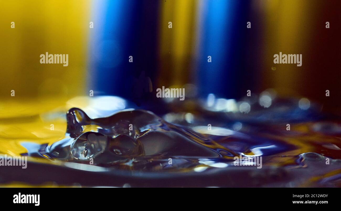 Water droplets falling on and bouncing off a pool of water, leaving ...