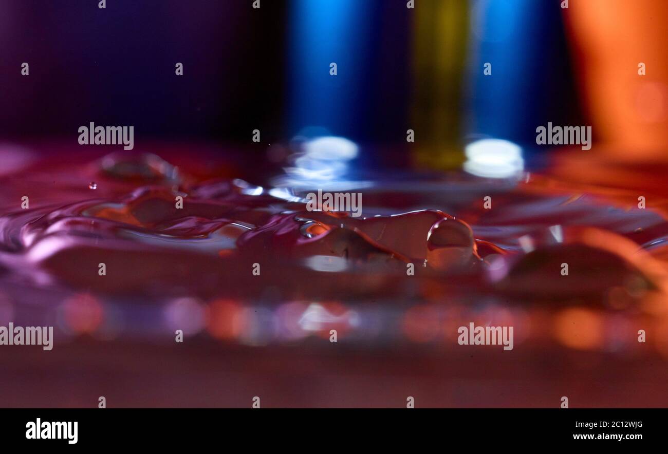 Water droplets falling on and bouncing off a pool of water, leaving ...