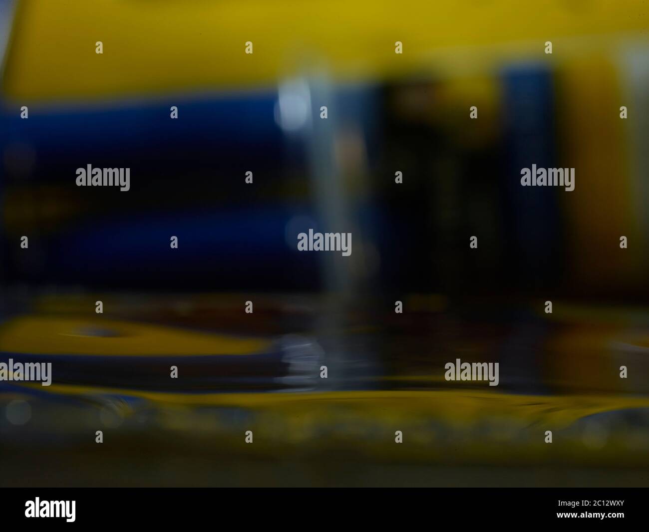Water droplets falling on and bouncing off a pool of water, leaving ...