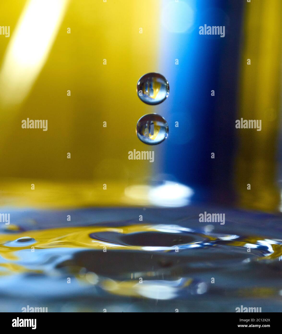 Water droplets falling on and bouncing off a pool of water, leaving ...