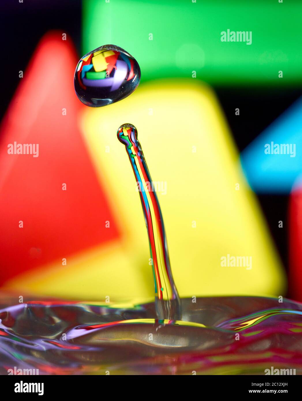 Water droplets falling on and bouncing off a pool of water, leaving ...