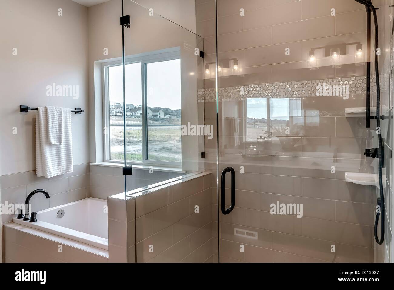 Frameless walk in shower stall and built in bathtub inside tile wall ...