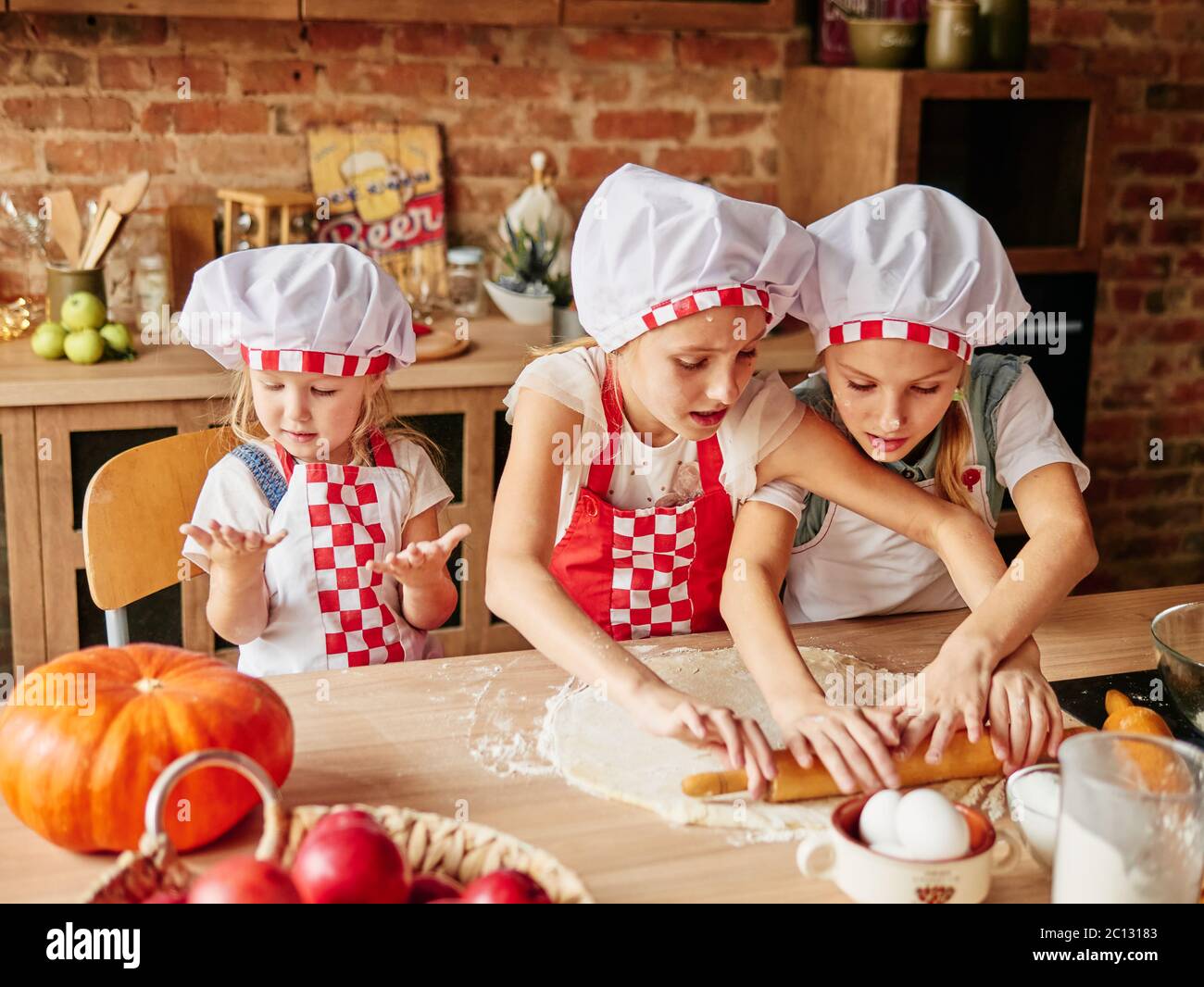 Three little chefs enjoying in the kitchen making big mess. Little ...
